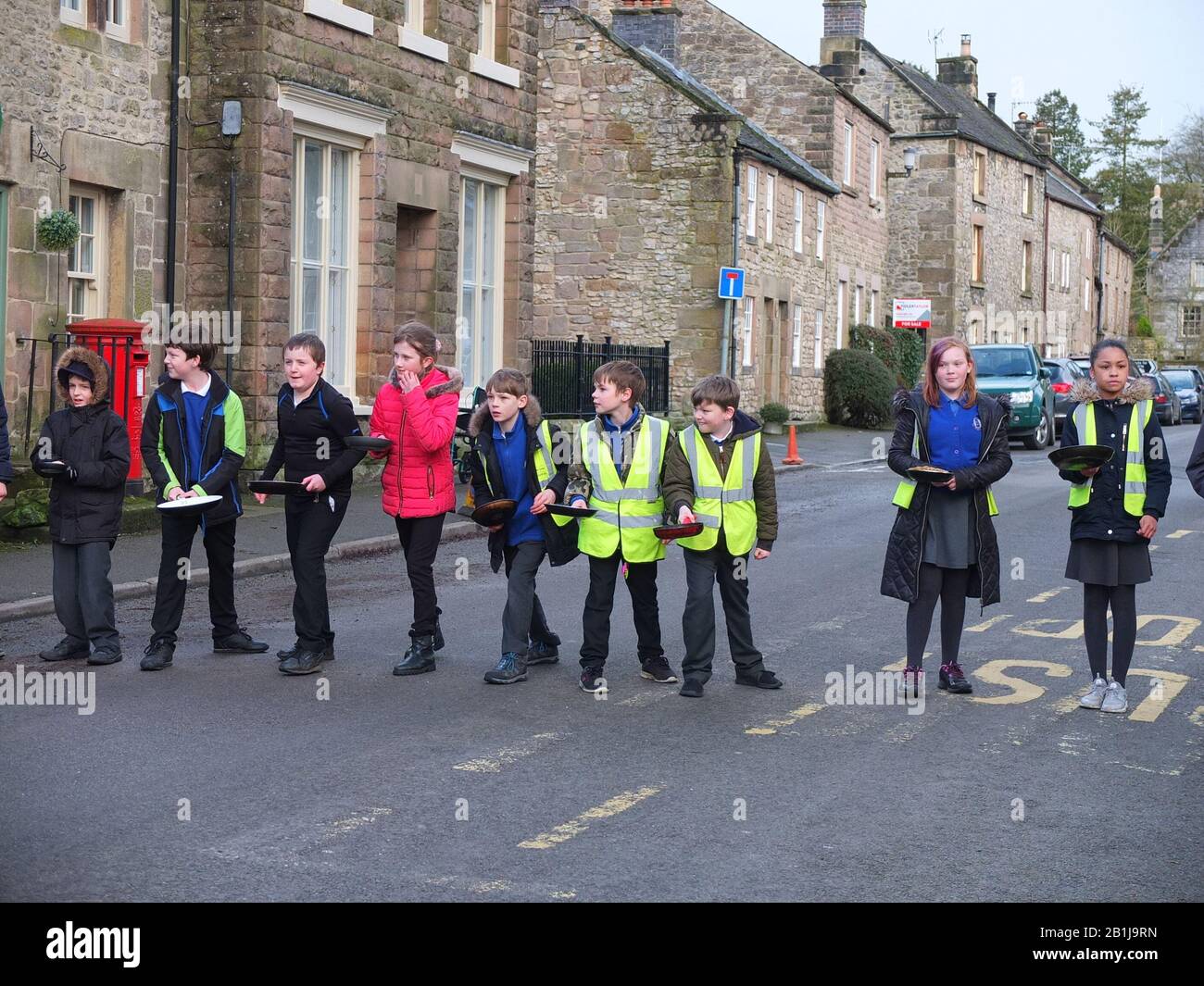 School children ready with frying pans and pancakes at starting line at ...