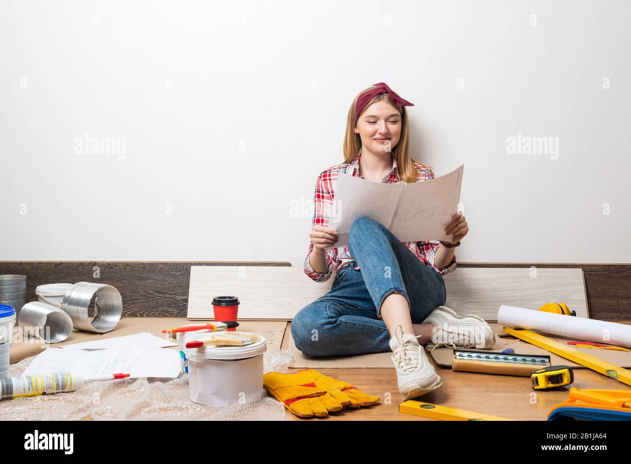 Beautiful girl sitting with paper blueprint Stock Photo - Alamy