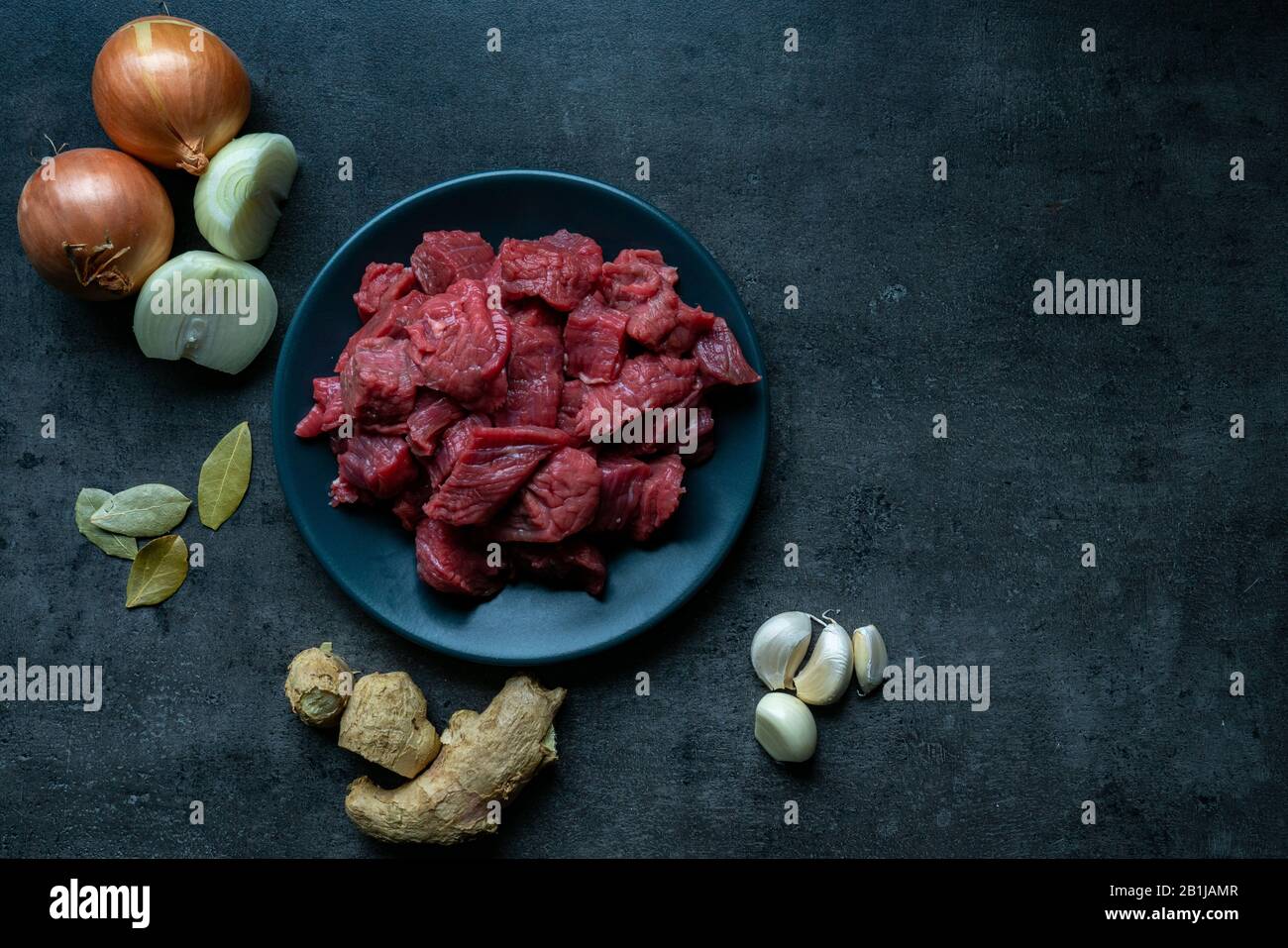 Top view of food ingredients, with meat, ingredients and beef on dark ...