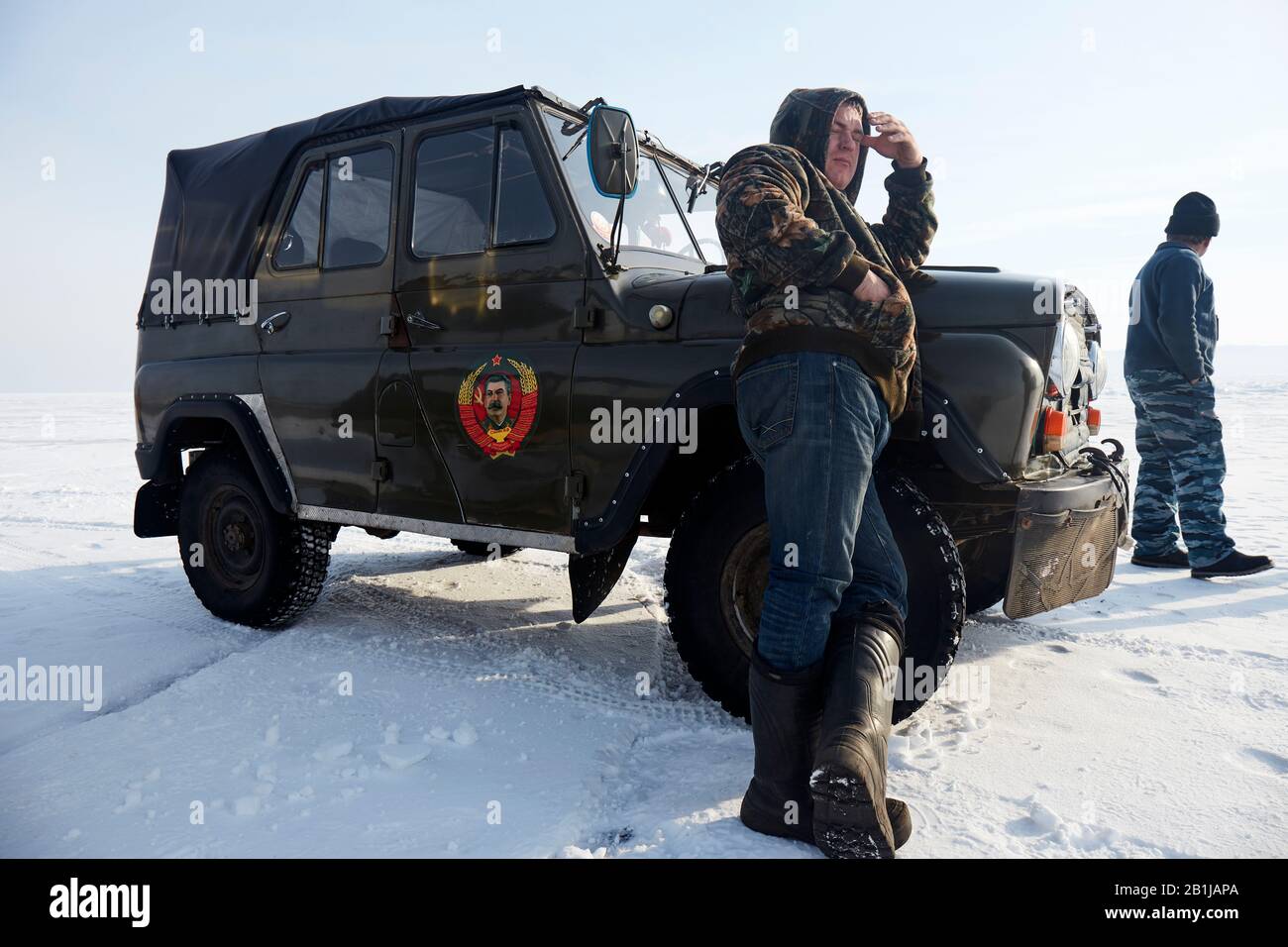 2 Russian men leaning on jeep like car with Stalin sticker Stock Photo ...