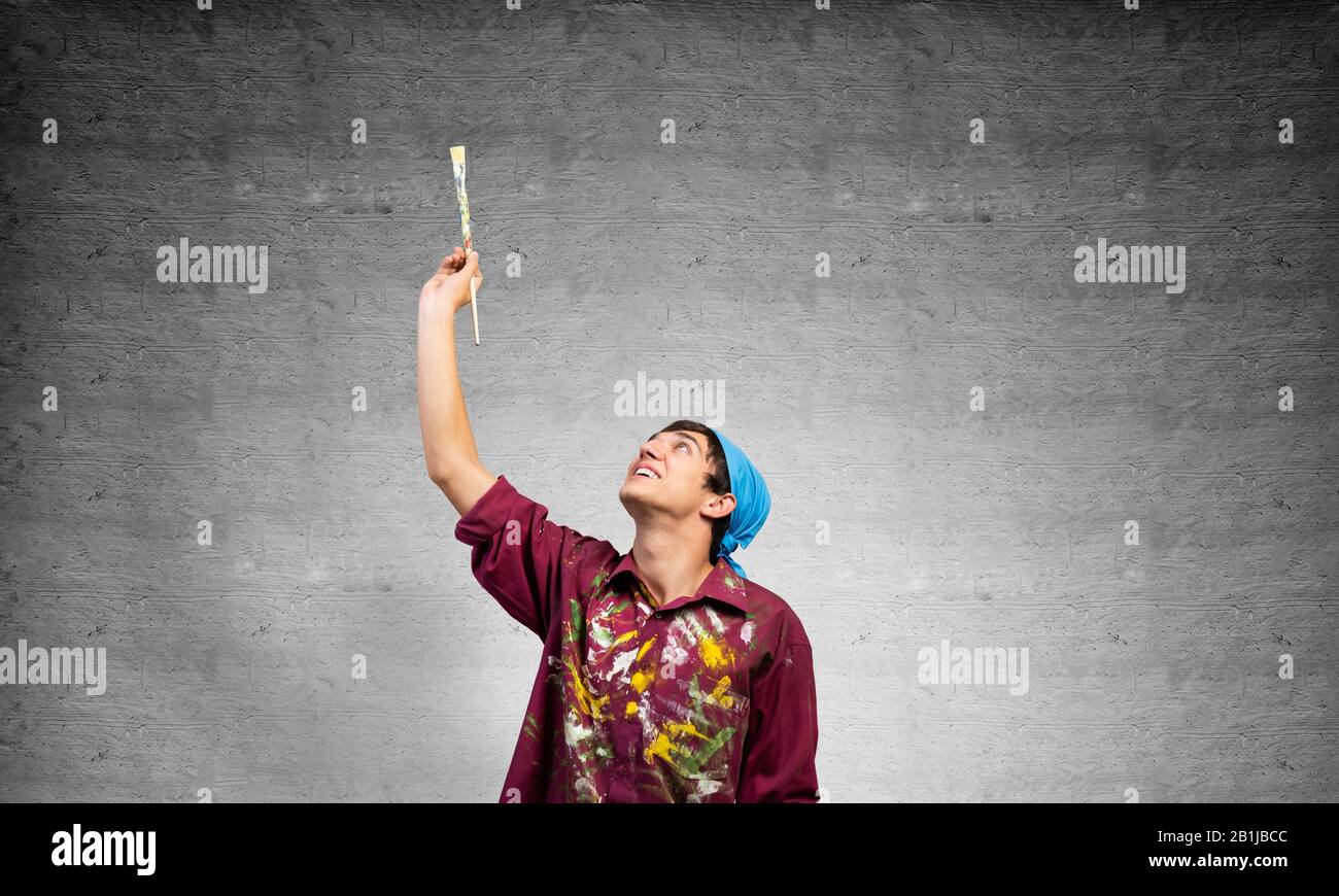 Young painter artist pointing upwards Stock Photo - Alamy