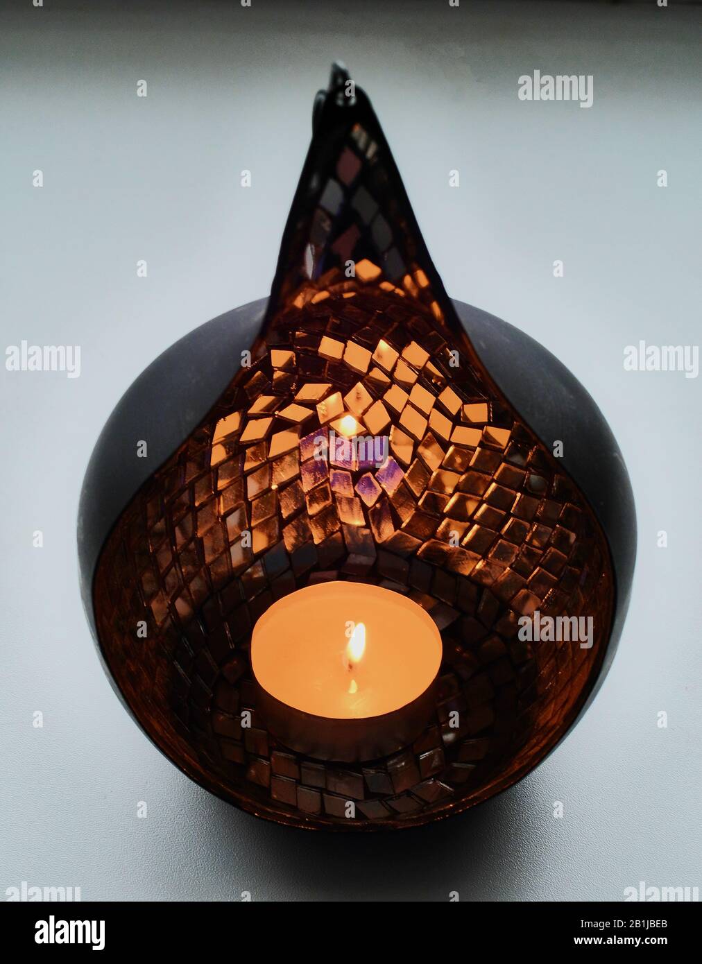 Burning candle in a candlestick from a sparkling mosaic Stock Photo - Alamy