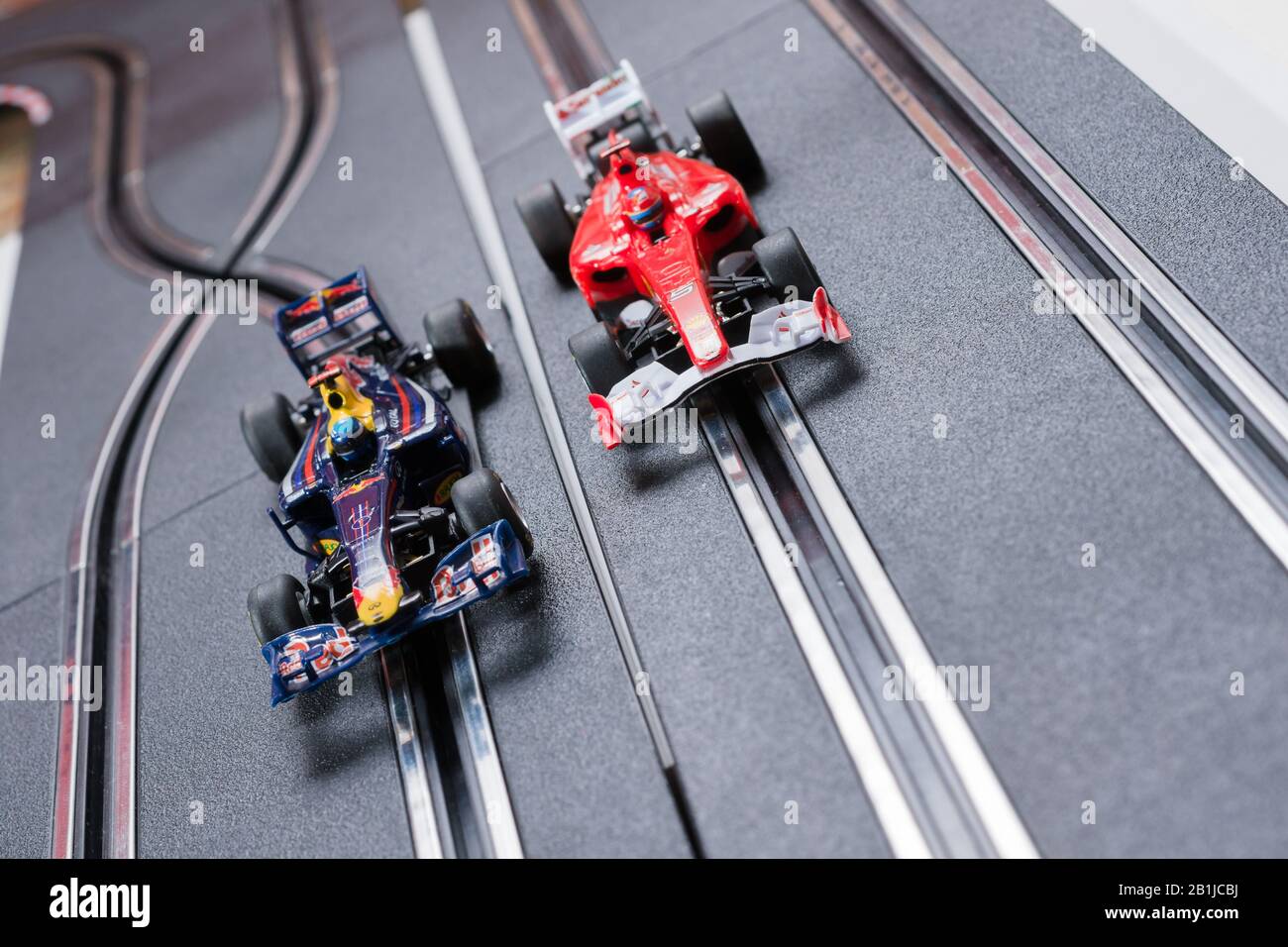 Model formula one Redbull and a Ferrari style slot cars racing on a ...