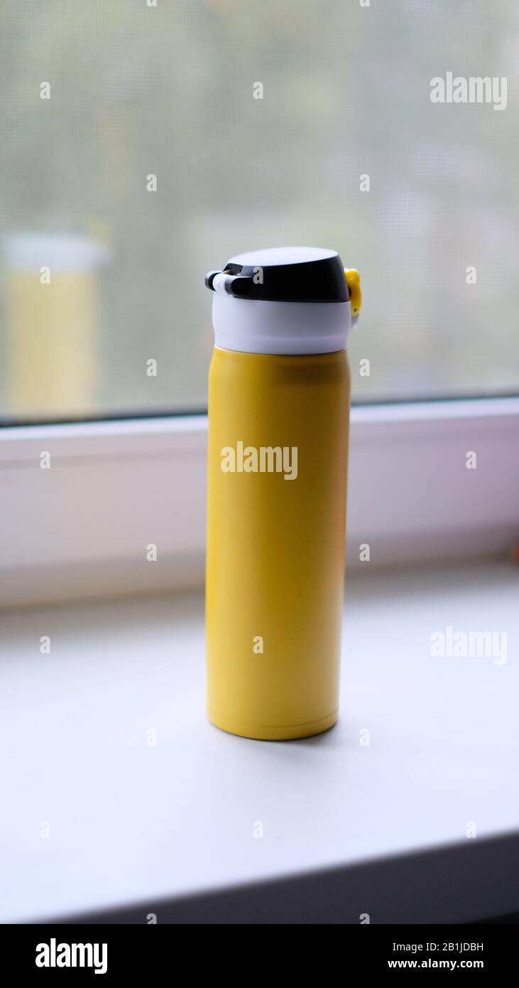 yellow thermos with black standing on the window Stock Photo - Alamy