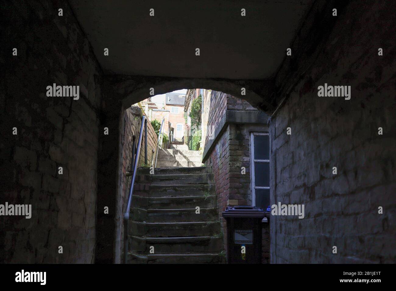 Stone steps rise through a brick passageway in Ashbourne, Derbyshire ...