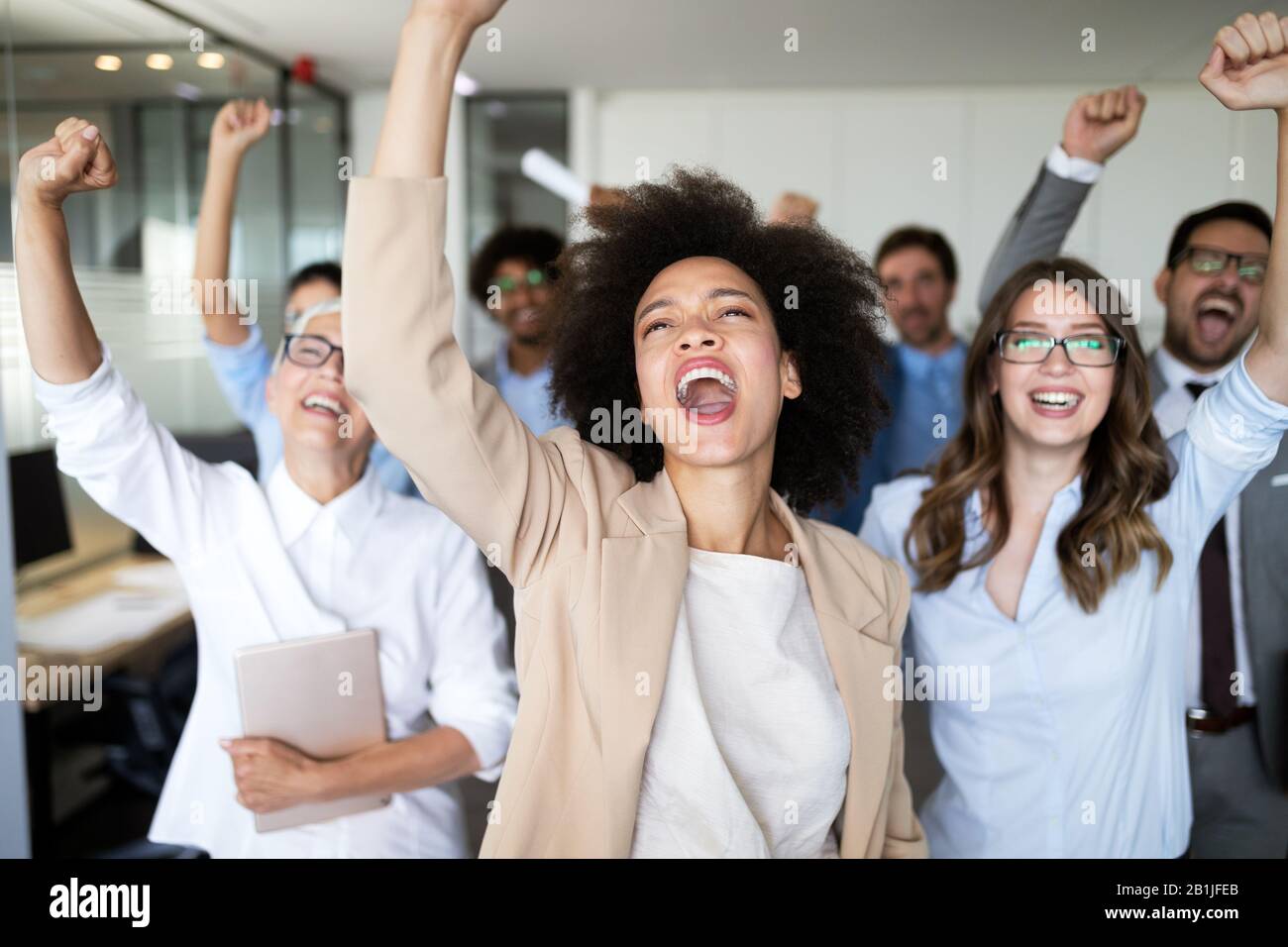 Happy business people celebrating success at company Stock Photo - Alamy