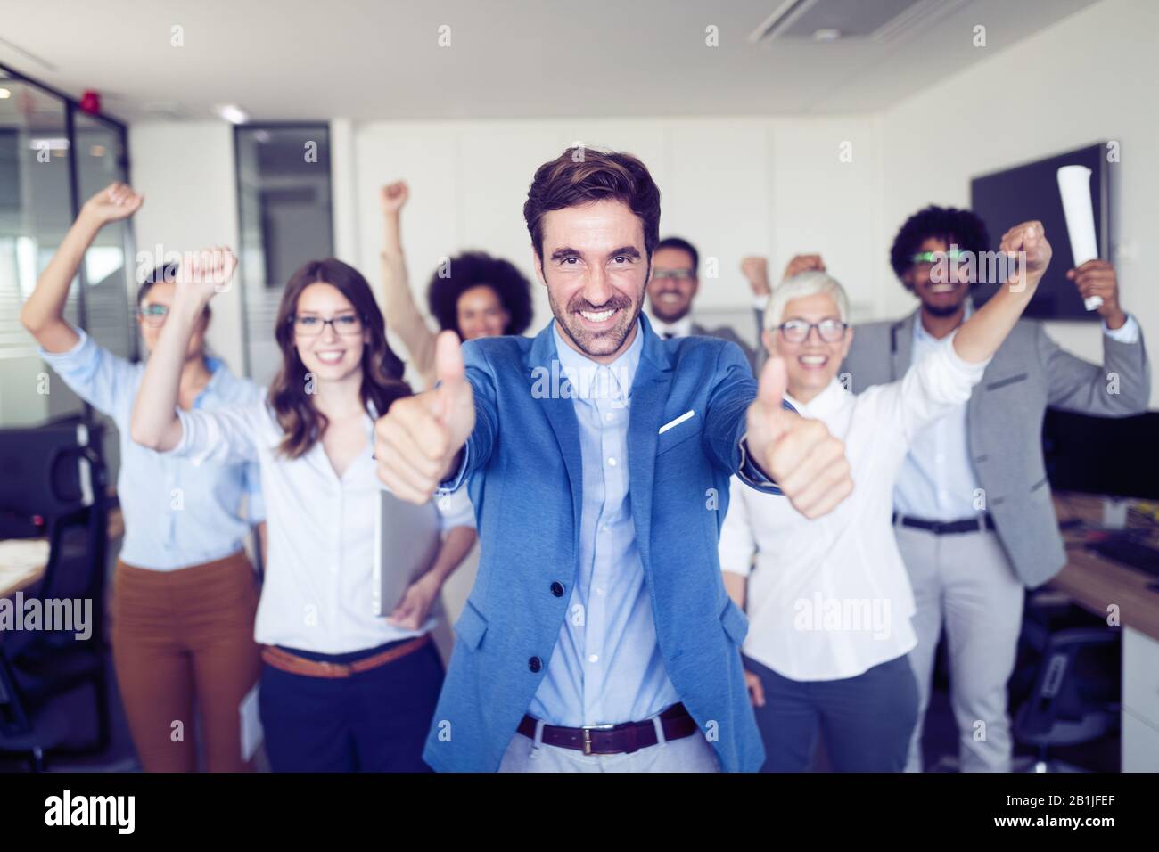 Happy business people celebrating success at company Stock Photo - Alamy