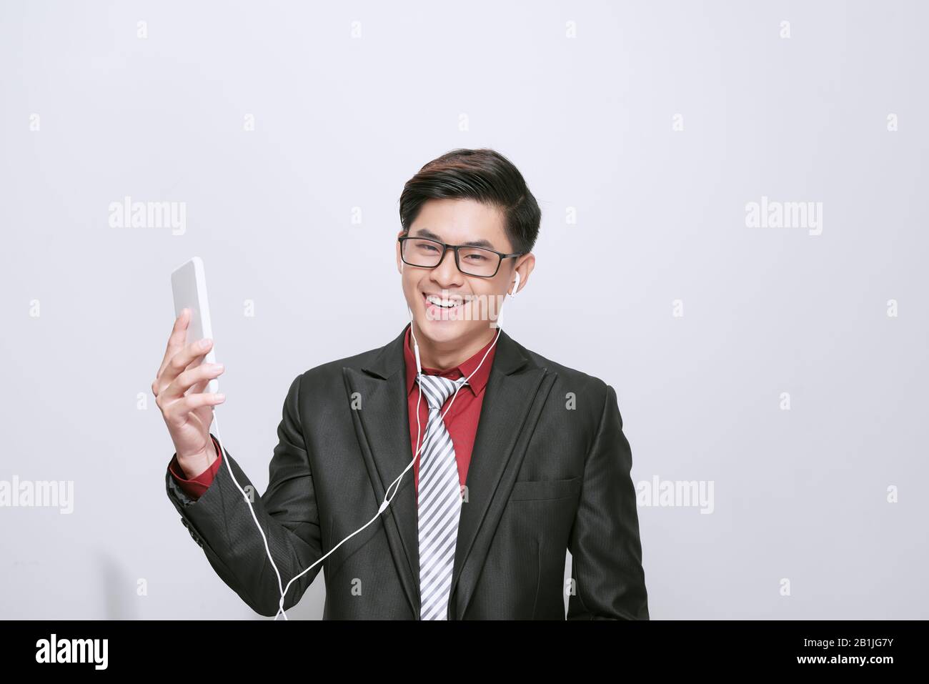 He hold mobile phone in front of himself and look at screen. Young man ...