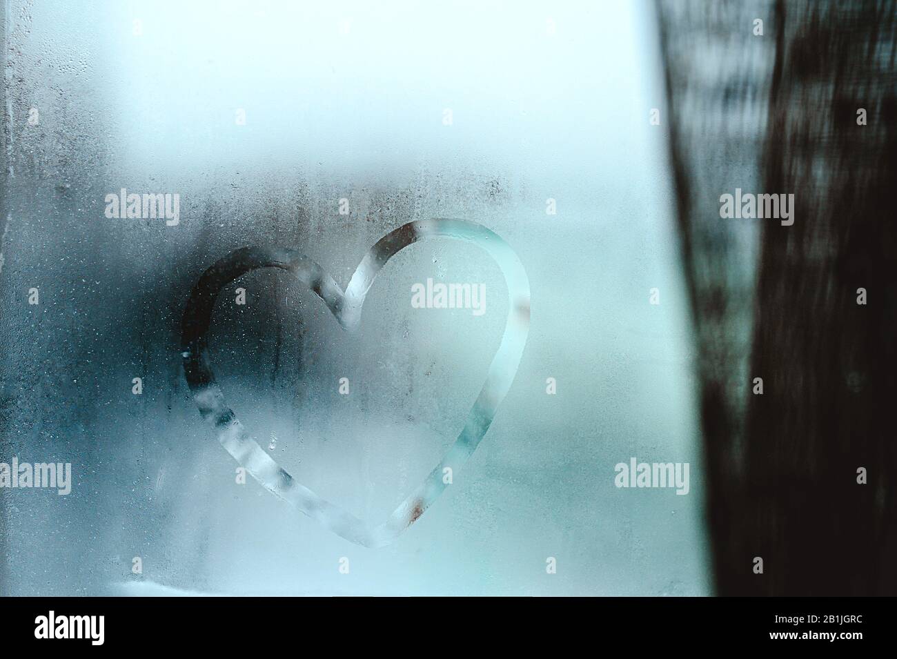 beautiful smooth heart is painted with a finger on wet sweaty glass, a ...