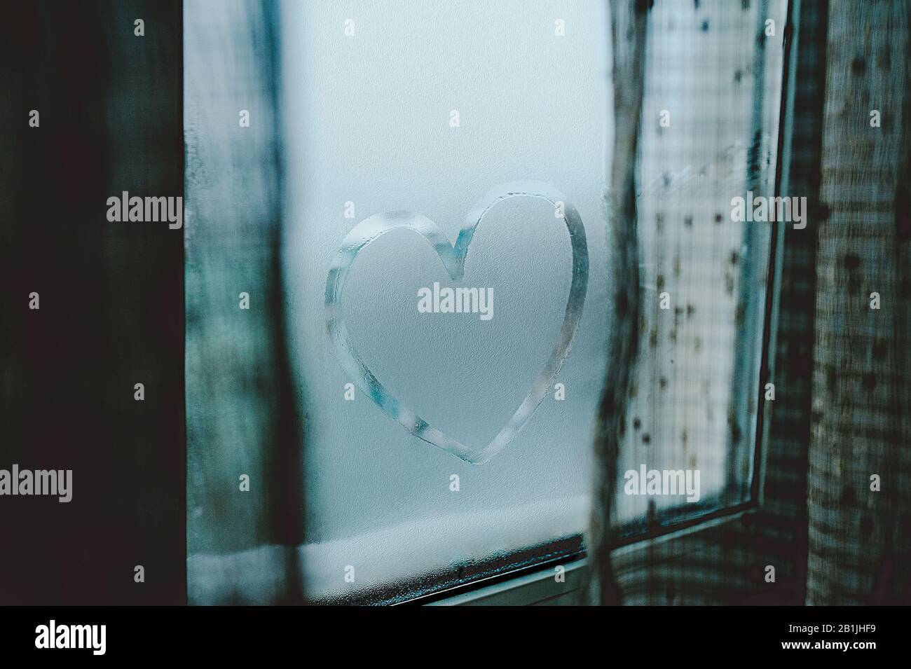 beautiful smooth heart is drawn with a finger on wet sweaty glass ...