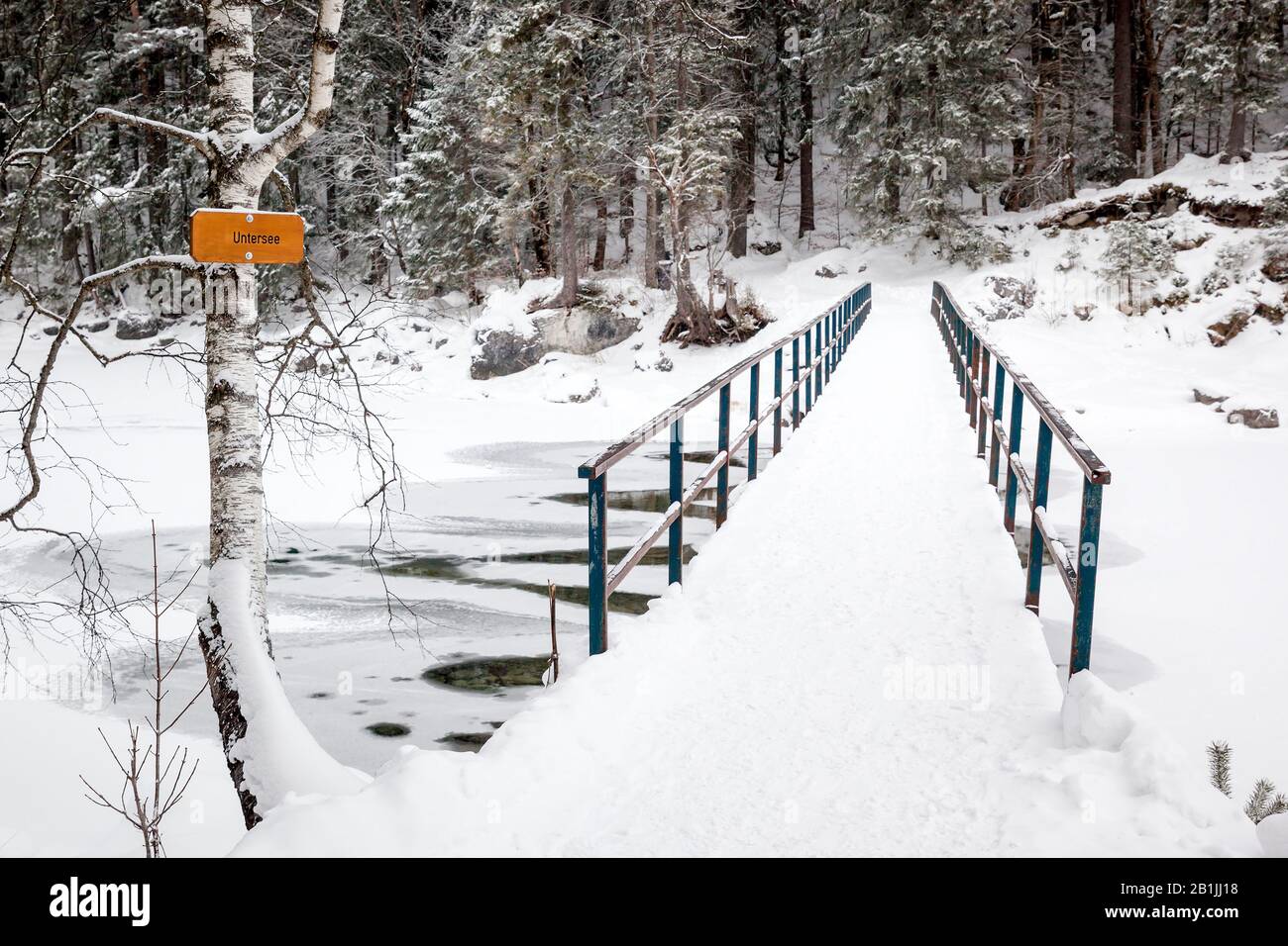 snow-covered bridge in front of a forest, Germany, Bavaria Stock Photo ...