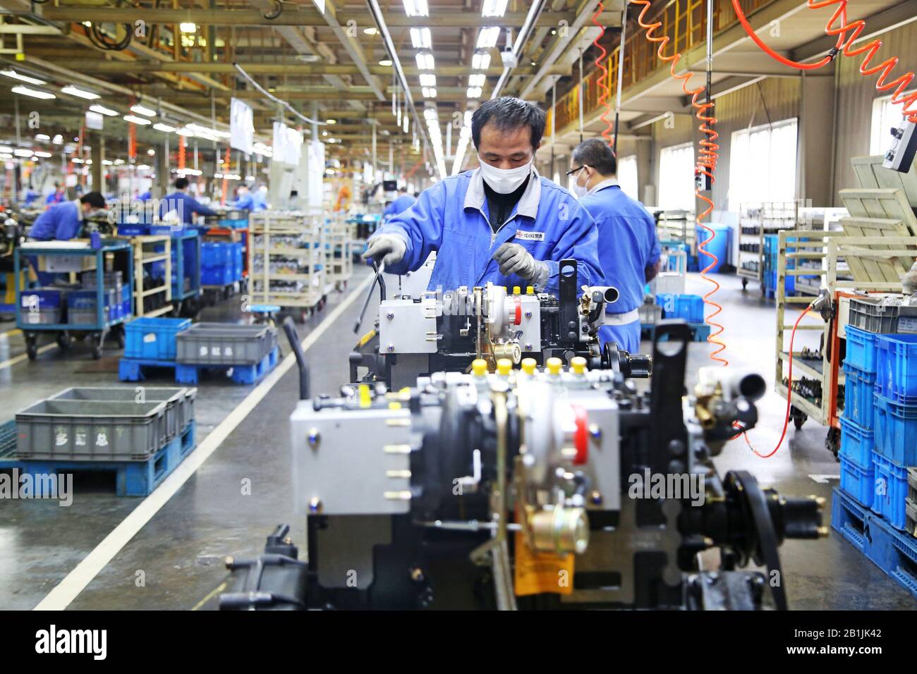 Chinese workers assemble agricultural machinery engines on the assembly ...