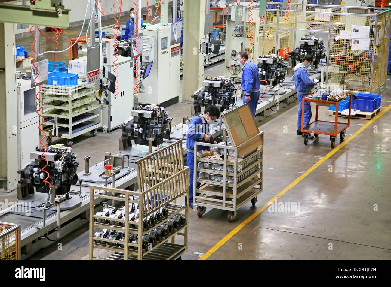 Chinese workers assemble agricultural machinery engines on the assembly ...