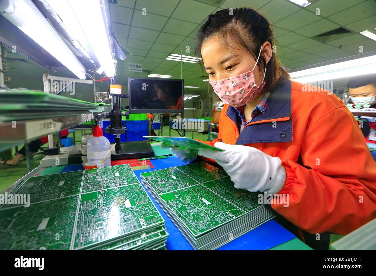 A Chinese worker manufactures printed circuit boards (PCB) which are ...