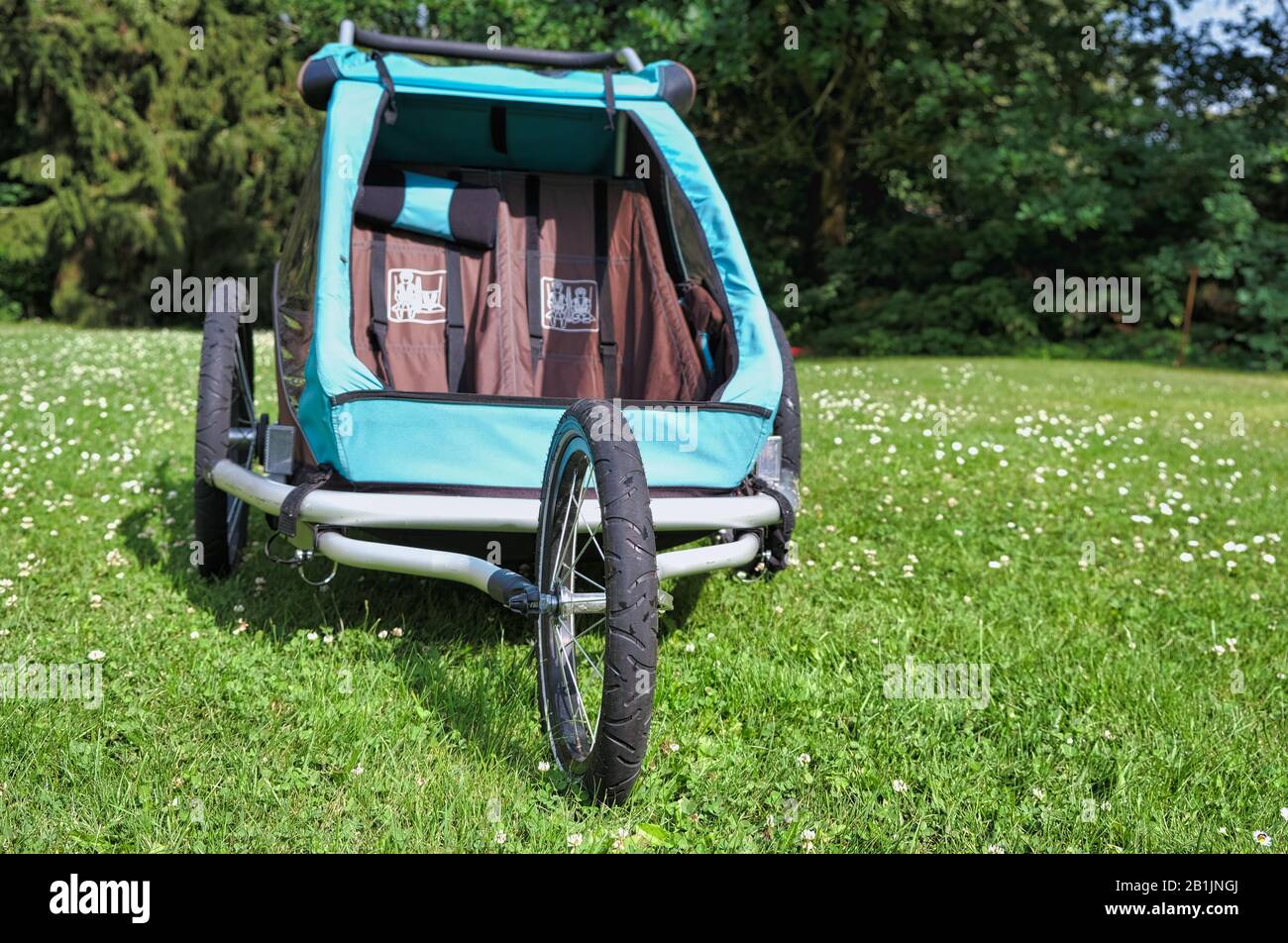 Vehicle to transport children on a green meadow Stock Photo - Alamy