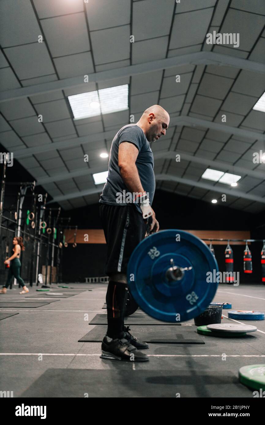 Adult bald man weightlifter exercising in gym Stock Photo - Alamy