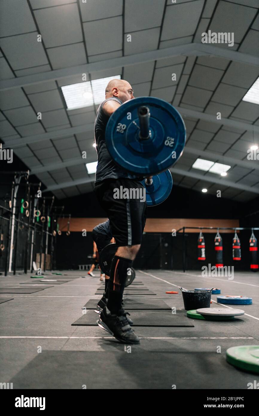 Adult bald man weightlifter exercising in gym Stock Photo - Alamy