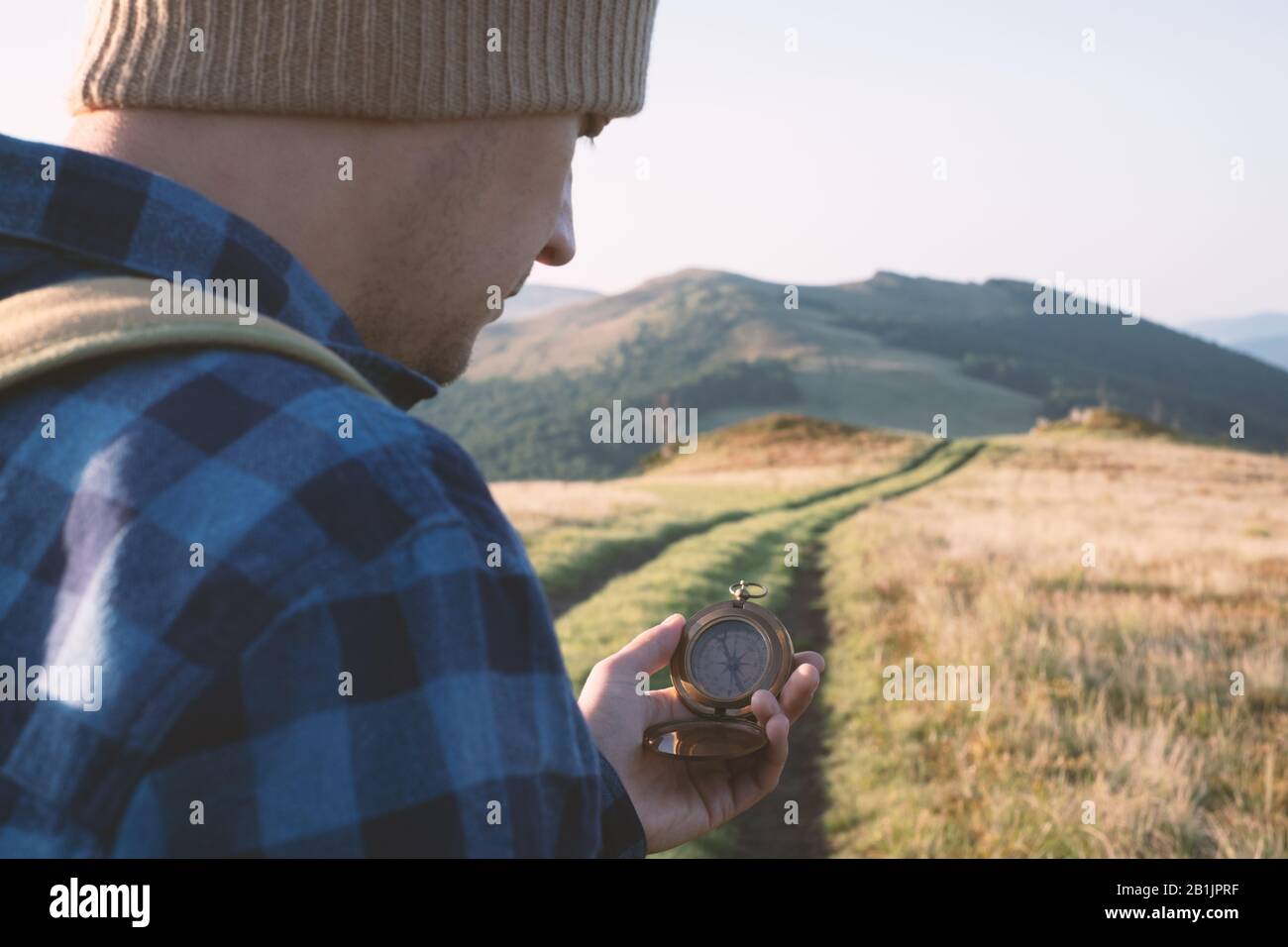 Man with old compass in hand on mountains road. Travel concept ...