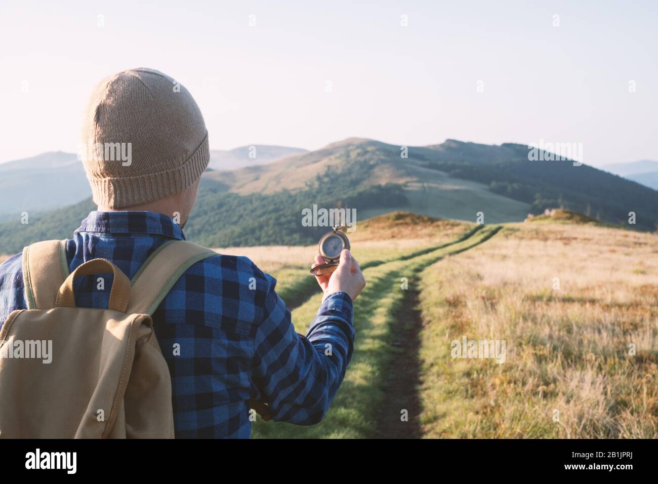 Man with old compass in hand on mountains road. Travel concept ...