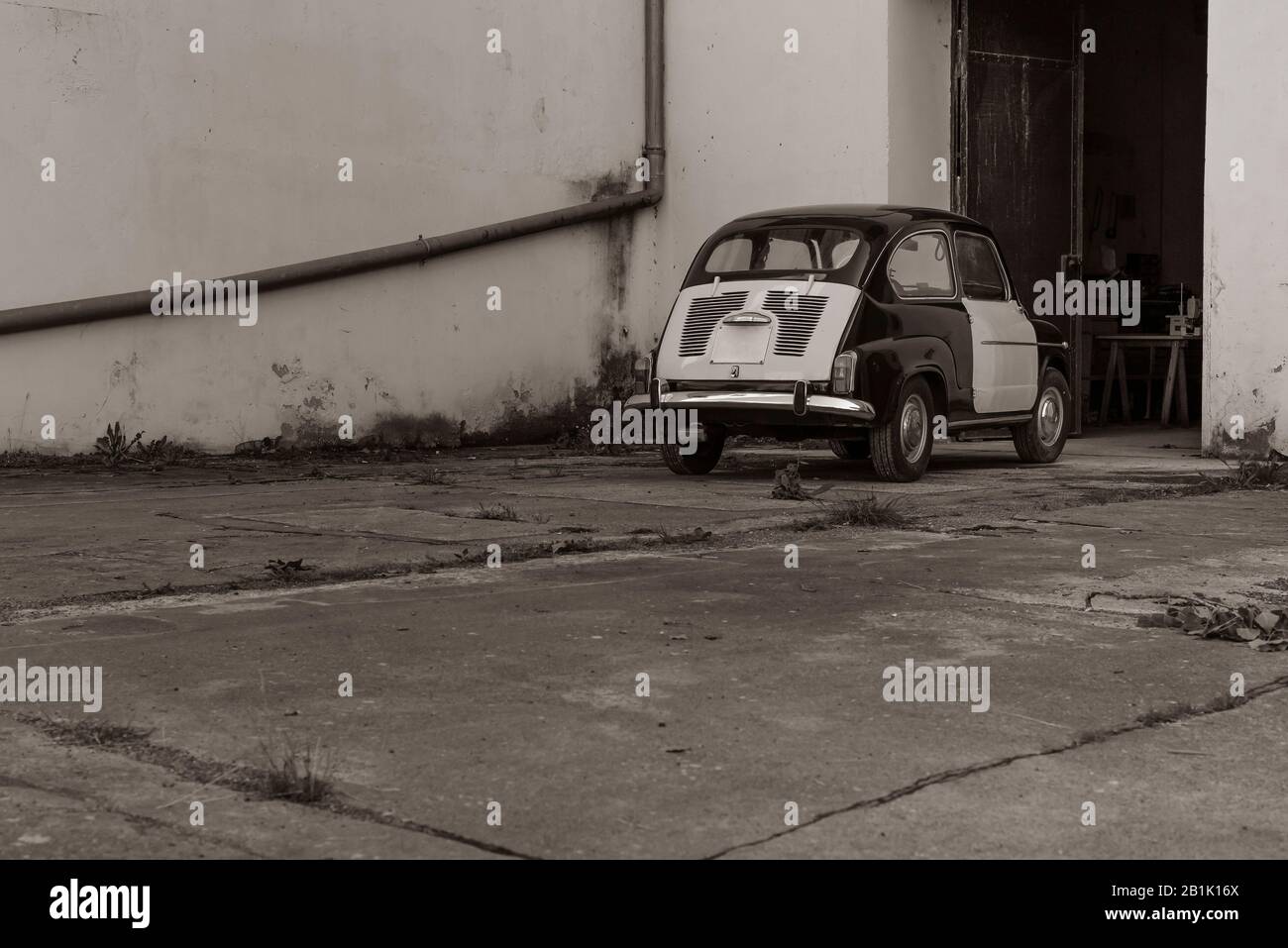 Old small car in front of a garage, small old car, old-timer, black and ...