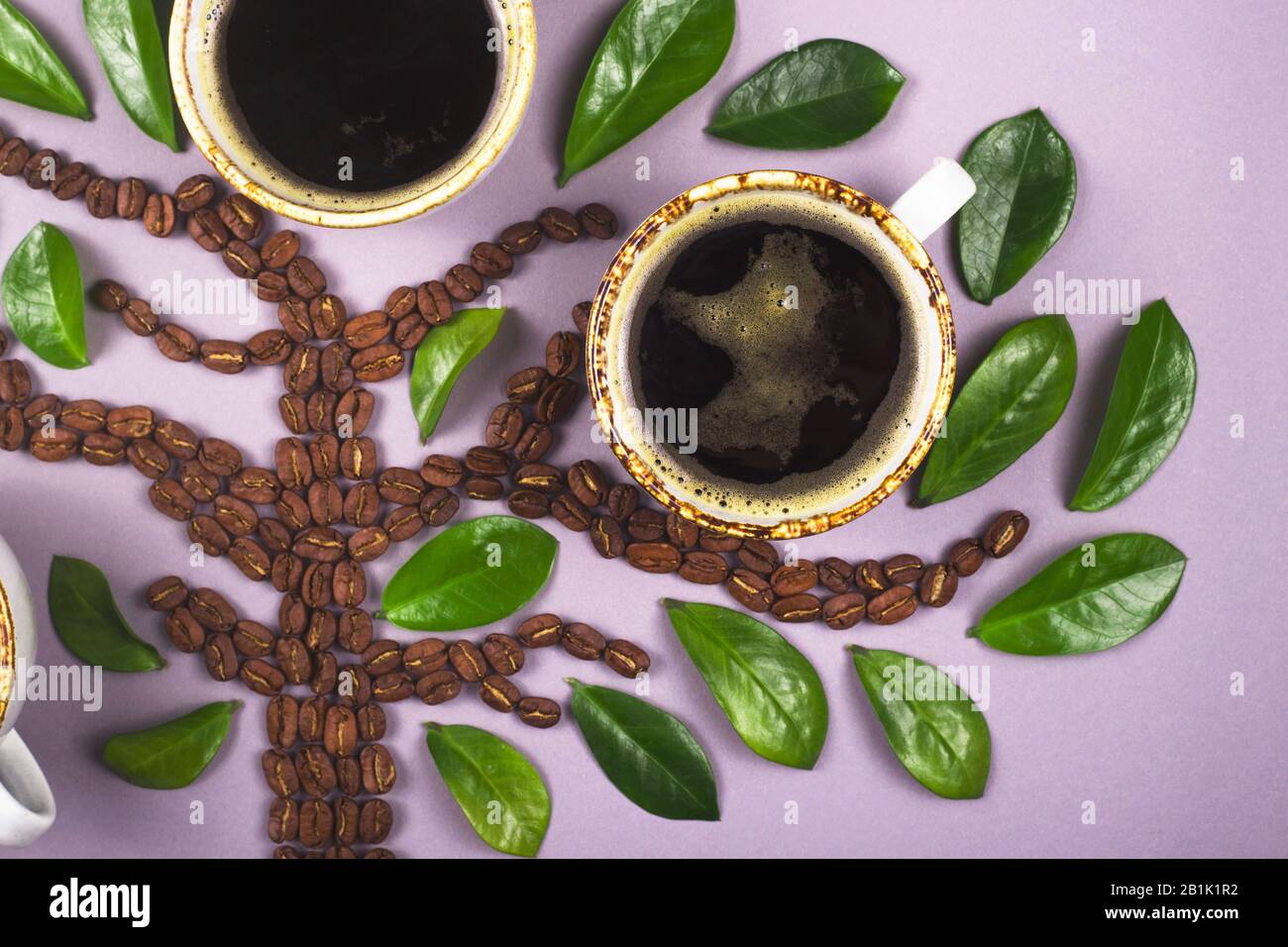 A tree-shaped layout made from coffee beans with cups of coffee grown ...