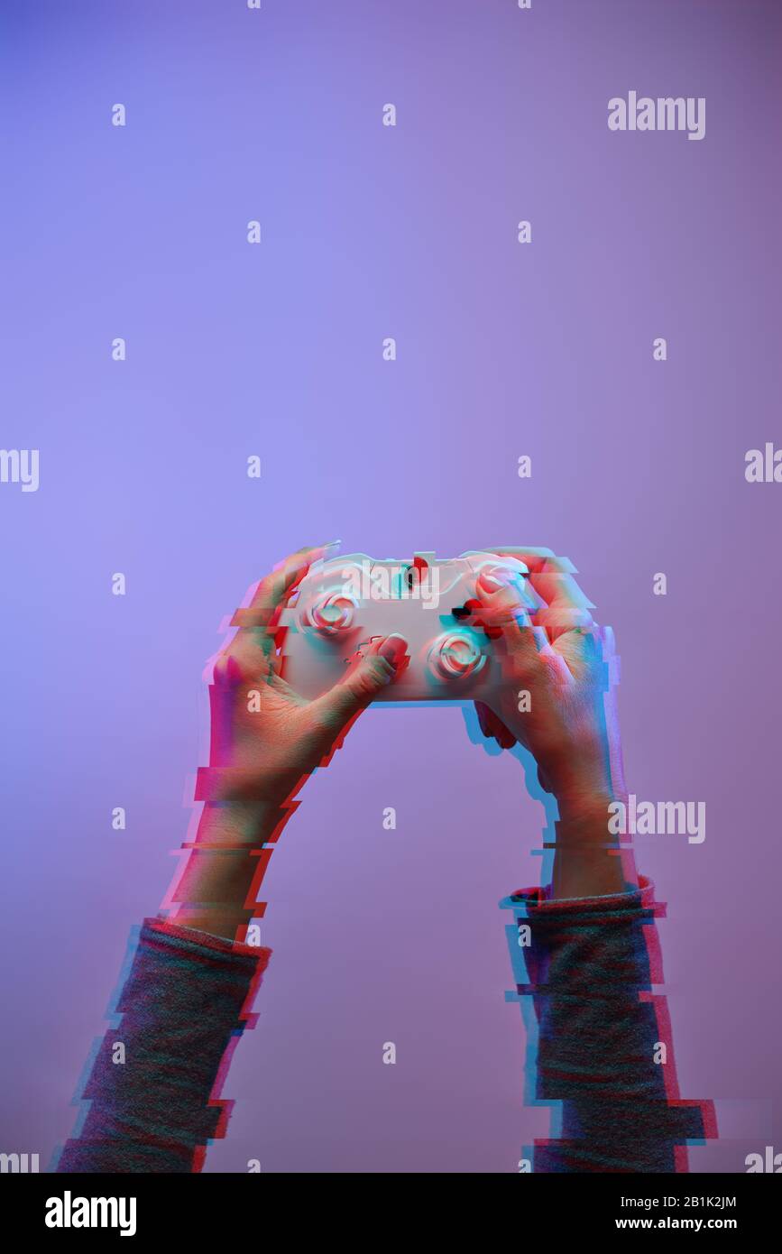 Female hands with a game joystick on violet background. Gamer concept ...