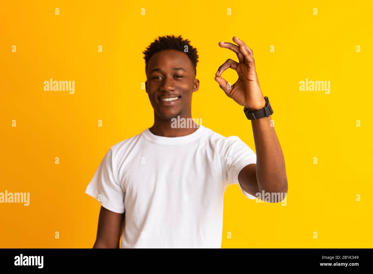 Young african guy smiling, gesturing and showing OK sign Stock Photo ...