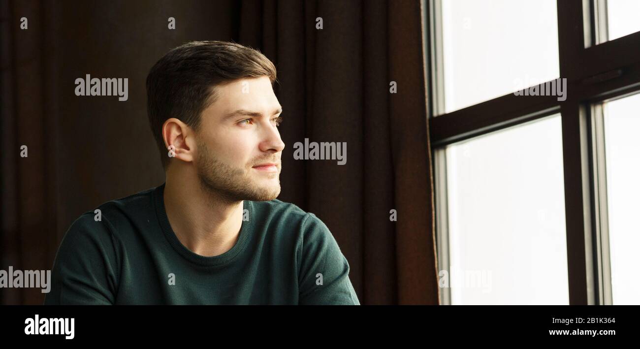 Young man sitting near window hi-res stock photography and images - Alamy