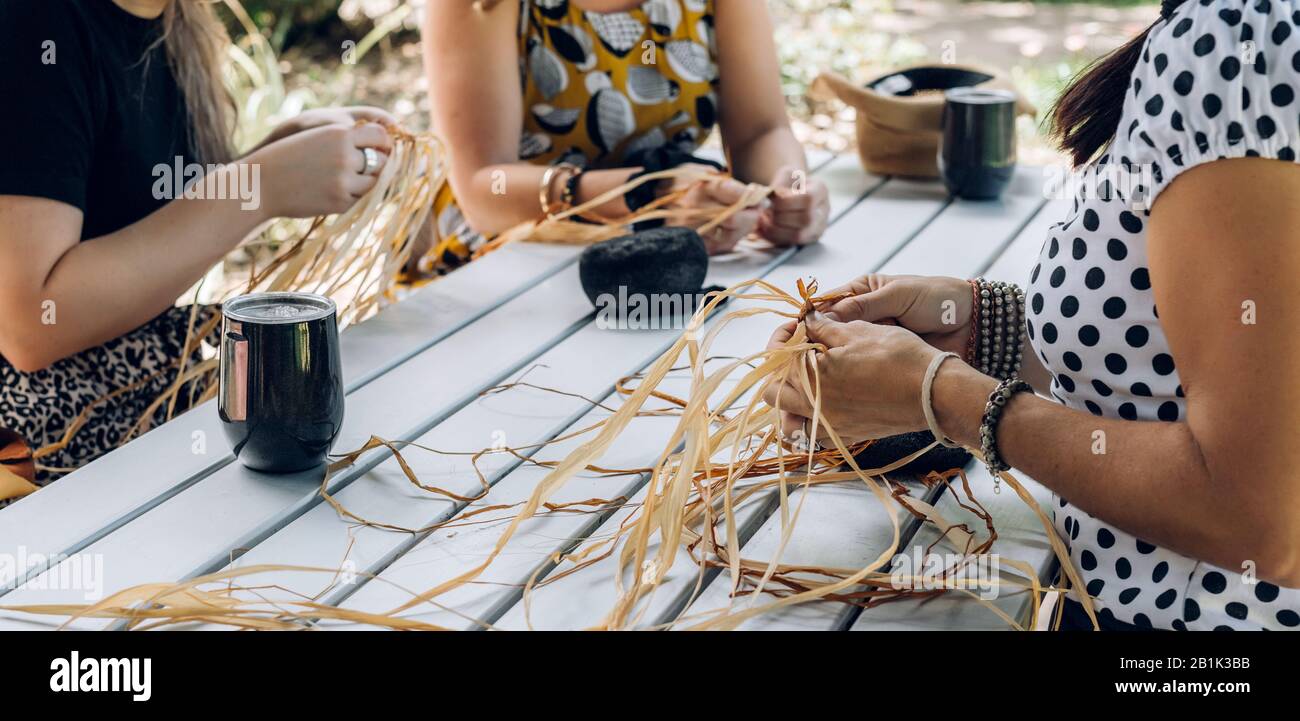 Females weaving baskets on the craft workshop. Hands holding the ...