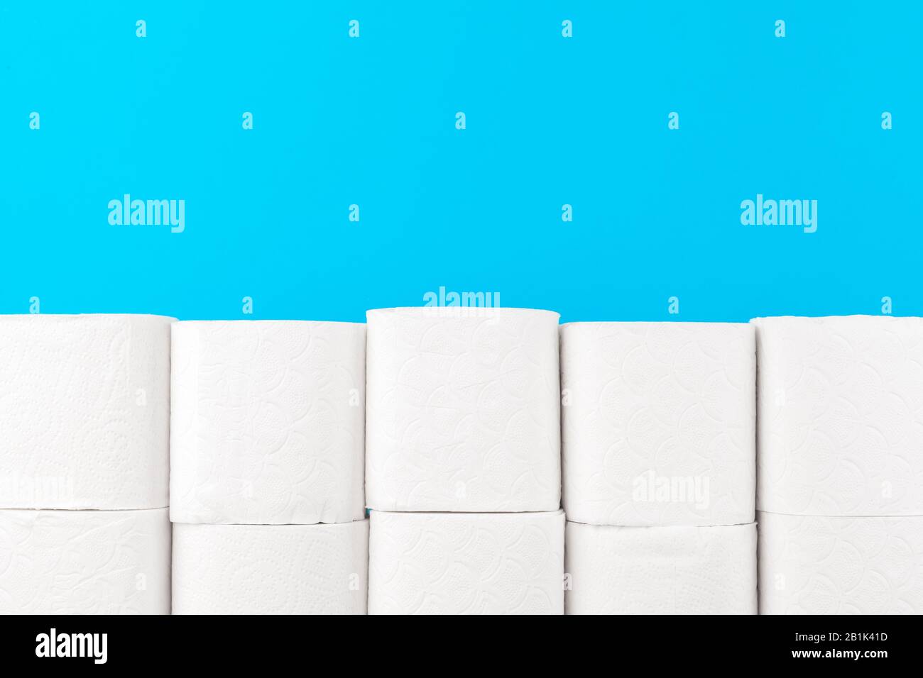 Toilet paper stack on bright blue background Stock Photo - Alamy