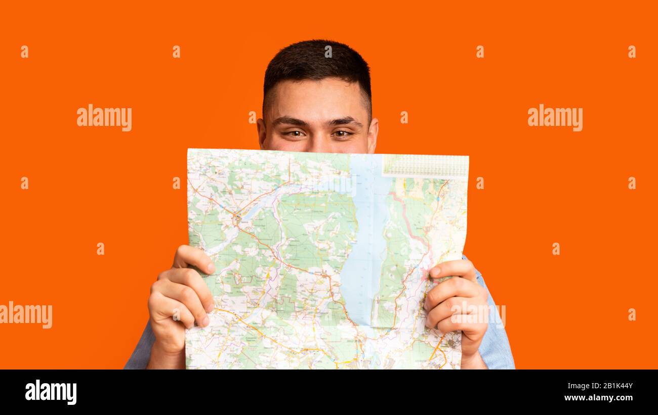 Inspired young man hiding behind city map Stock Photo - Alamy