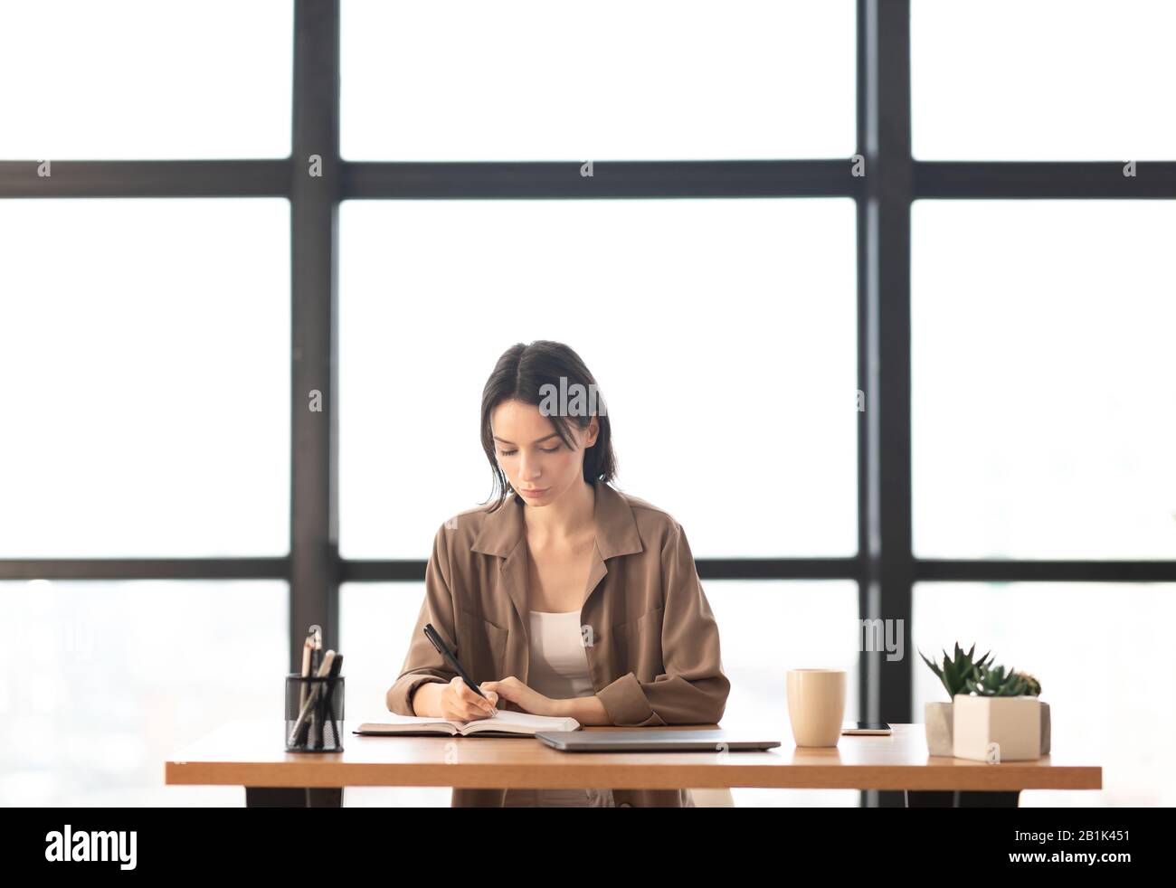Confident woman taking down notes and ideas Stock Photo - Alamy