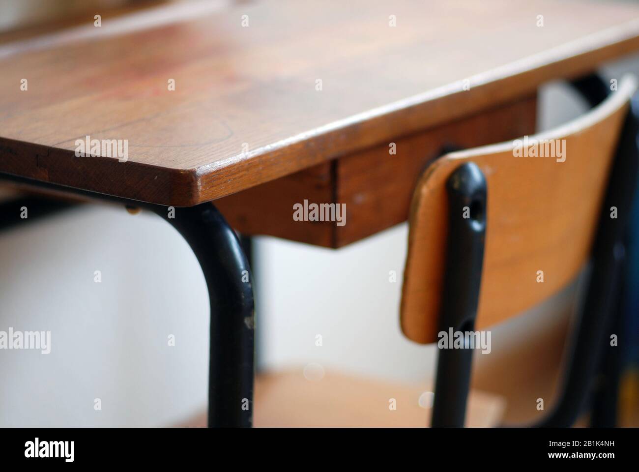 Detail of an wooden old classroom table and a chair Stock Photo - Alamy
