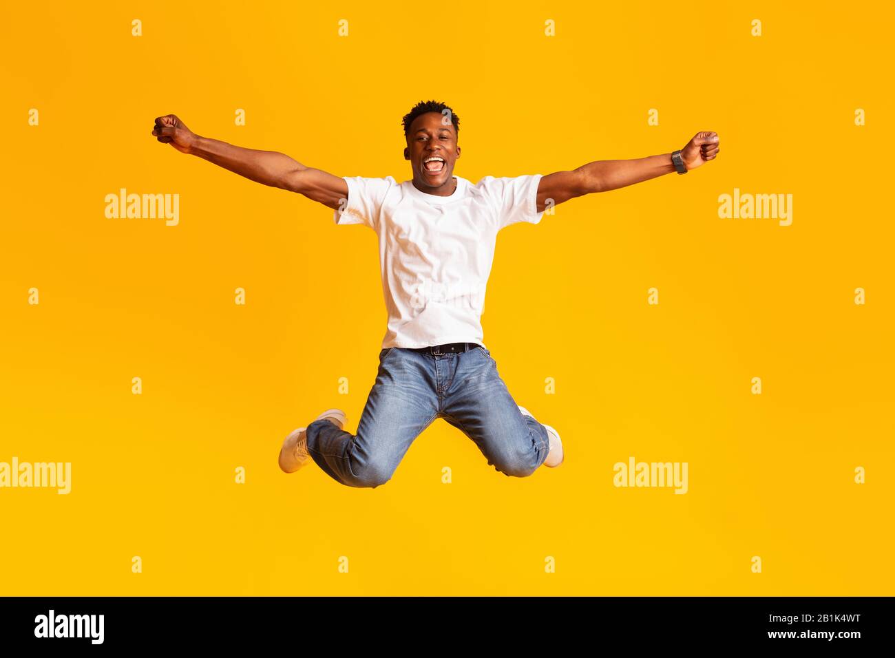 Happy excited african man jumping in air, dancing Stock Photo - Alamy