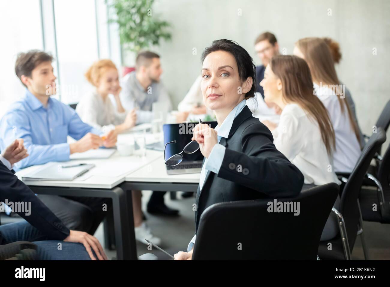 Confident CEO smiling to camera at meeting Stock Photo - Alamy
