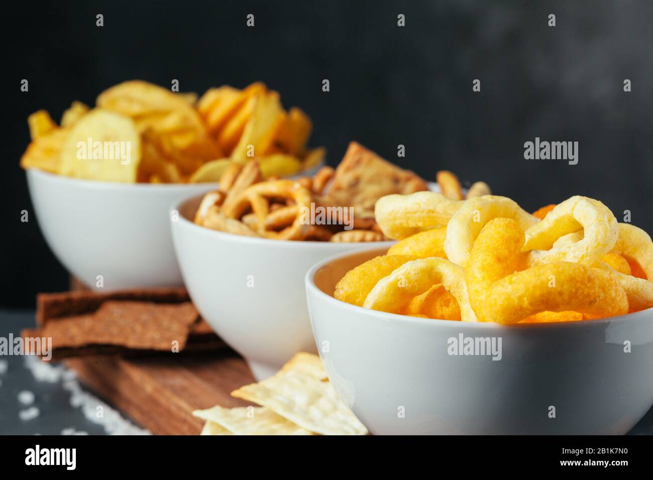 Beer snacks on stone table. Various crackers, potato chips. Top view ...