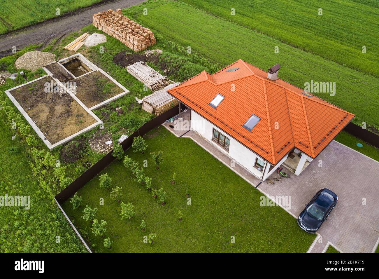 Aerial top view of a private house with attic windows on roof, paved ...