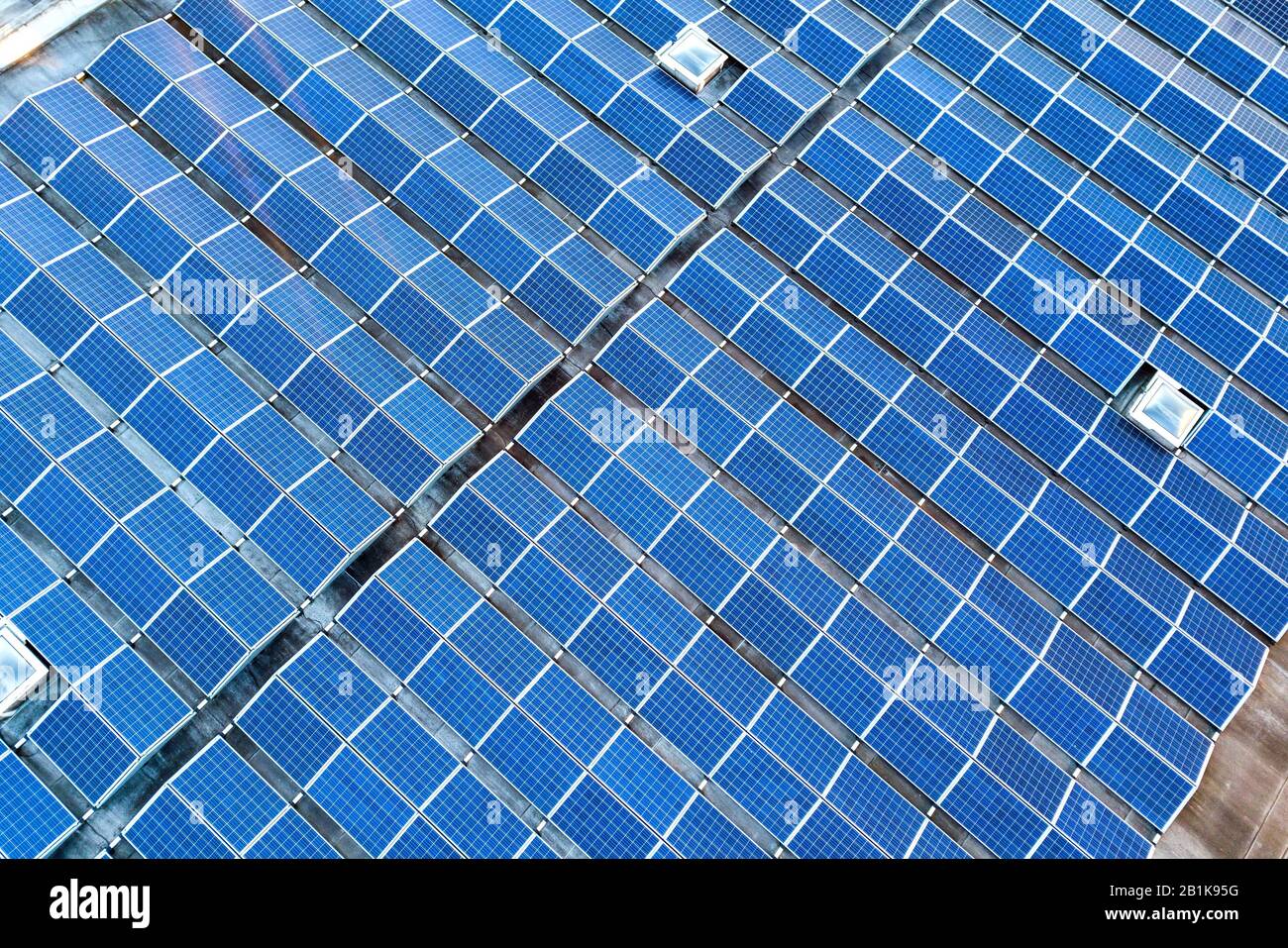 Aerial view of many photo voltaic solar panels mounted of industrial ...