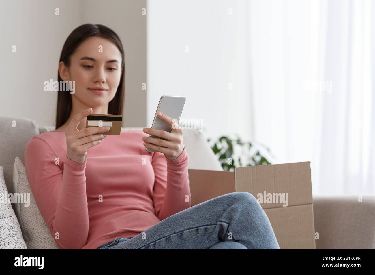 Successful young woman making transaction using mobile bank Stock Photo ...