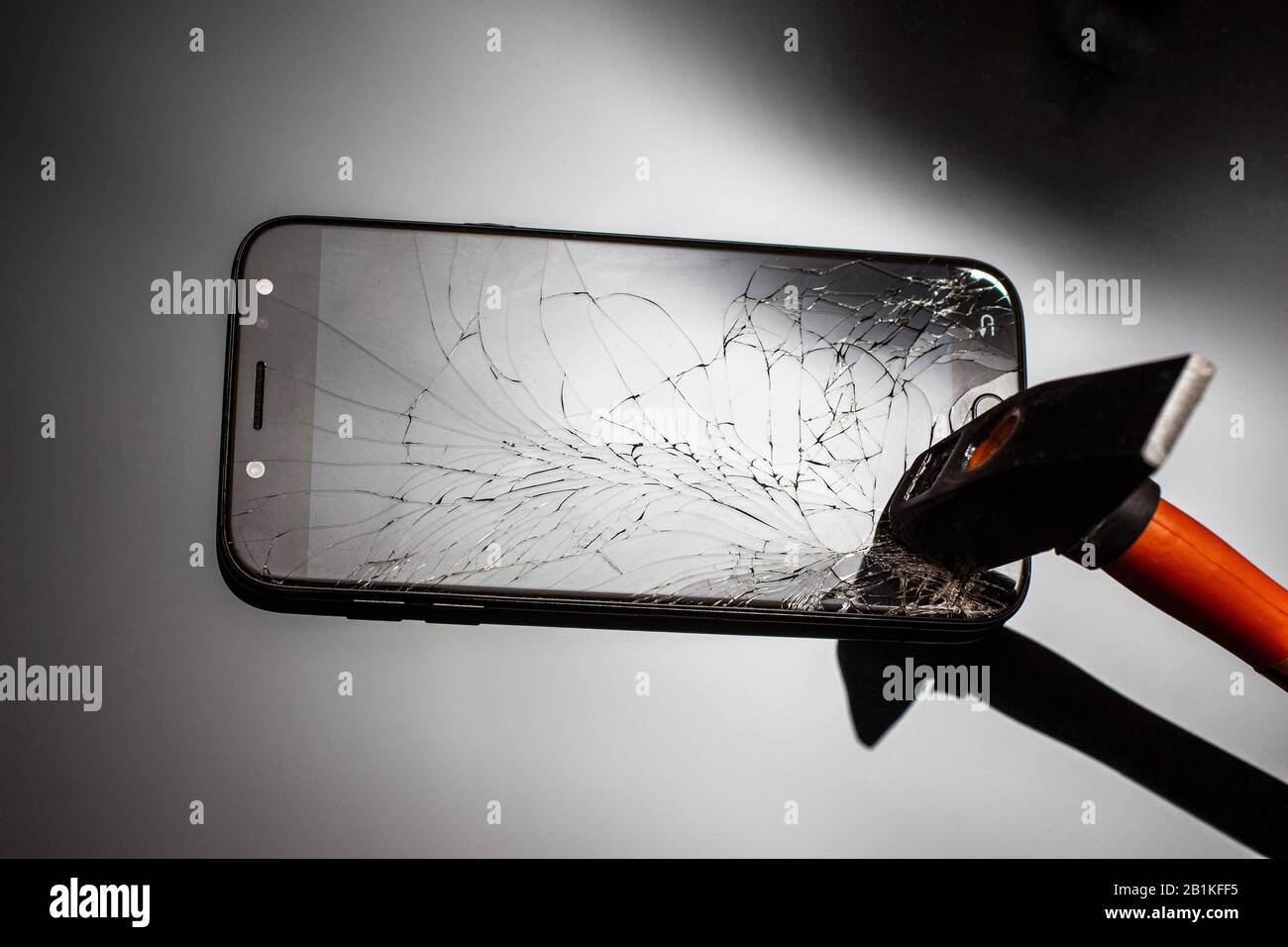 The smartphone is broken by a hammer on a black background Stock Photo ...