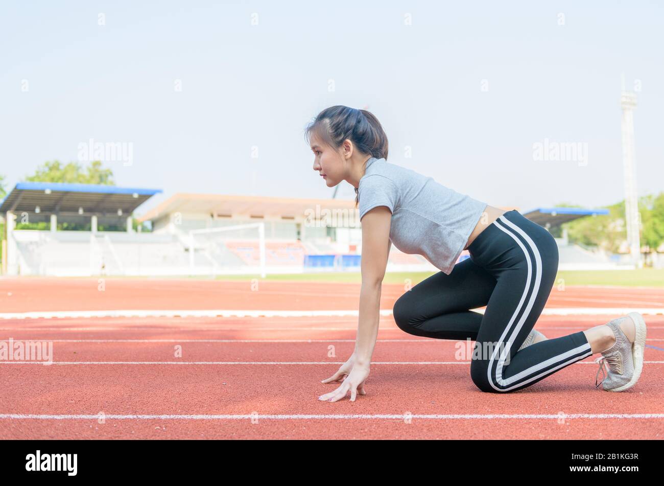 Side view of Asian cute athlete on a race track is ready to run, runner ...