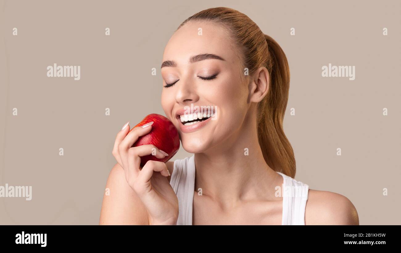 Woman Biting Red Apple Posing Standing Over Beige Background Stock ...