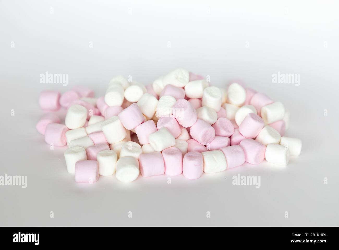 Pink and white mini marshmallows on white background, sweet food Stock ...