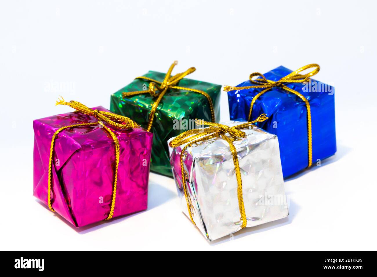 Four gift boxes with golden ribbon isolated on white Stock Photo - Alamy