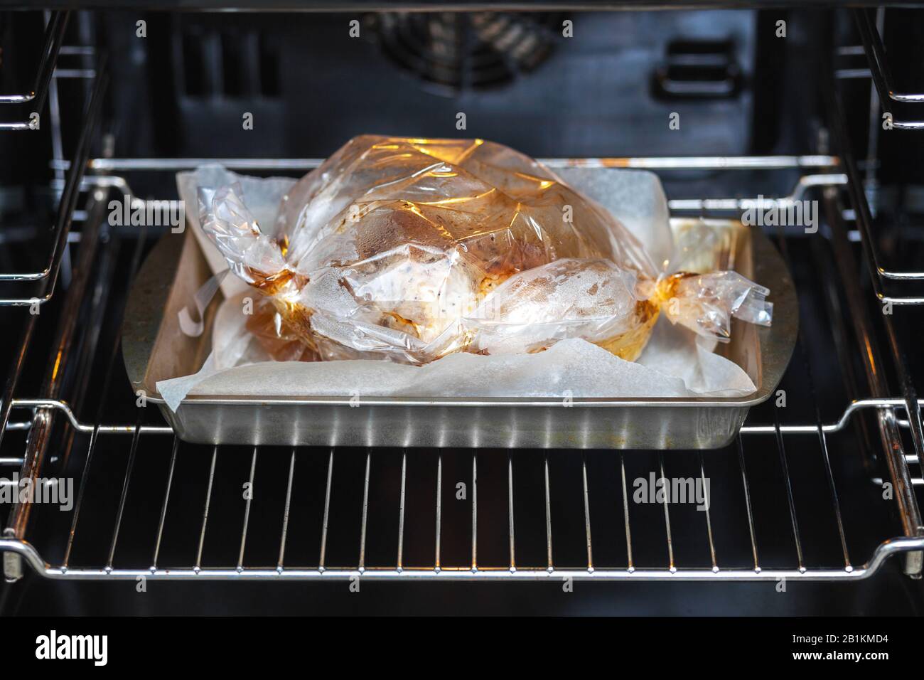 The meat is baked in a sleeve on a metal baking sheet in the oven Stock ...
