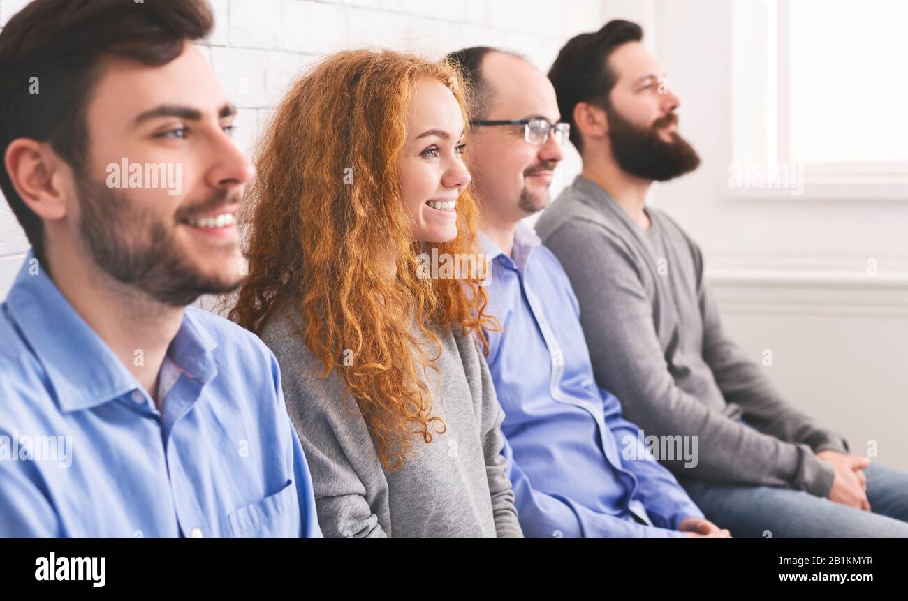 Happy people sitting in a row and listening speaker during workshop ...
