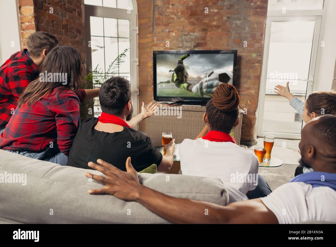 Excited group of people watching football, soccer sport match at home ...