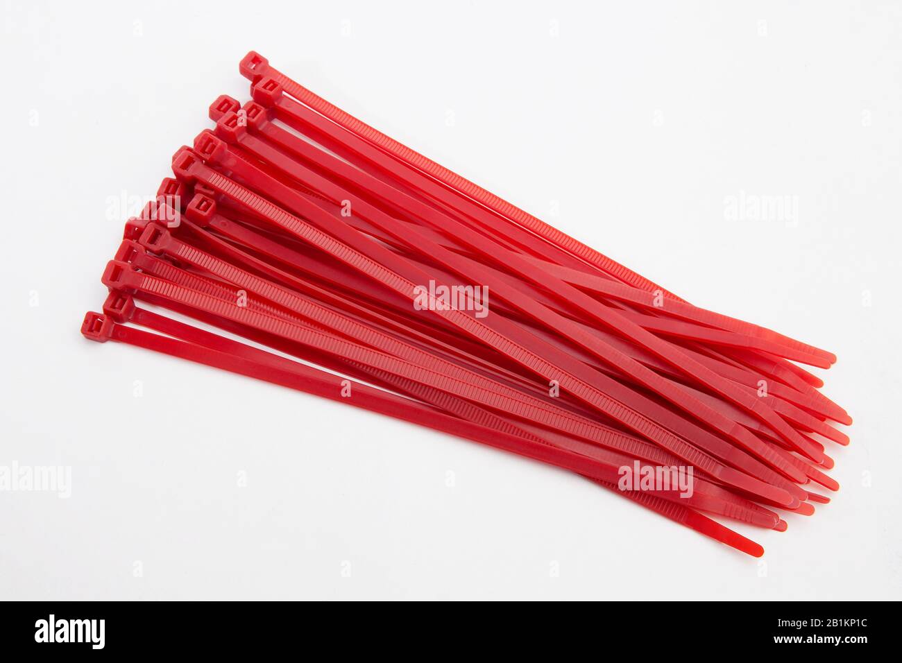 Cable tie in red, isolated in front of white background Stock Photo - Alamy