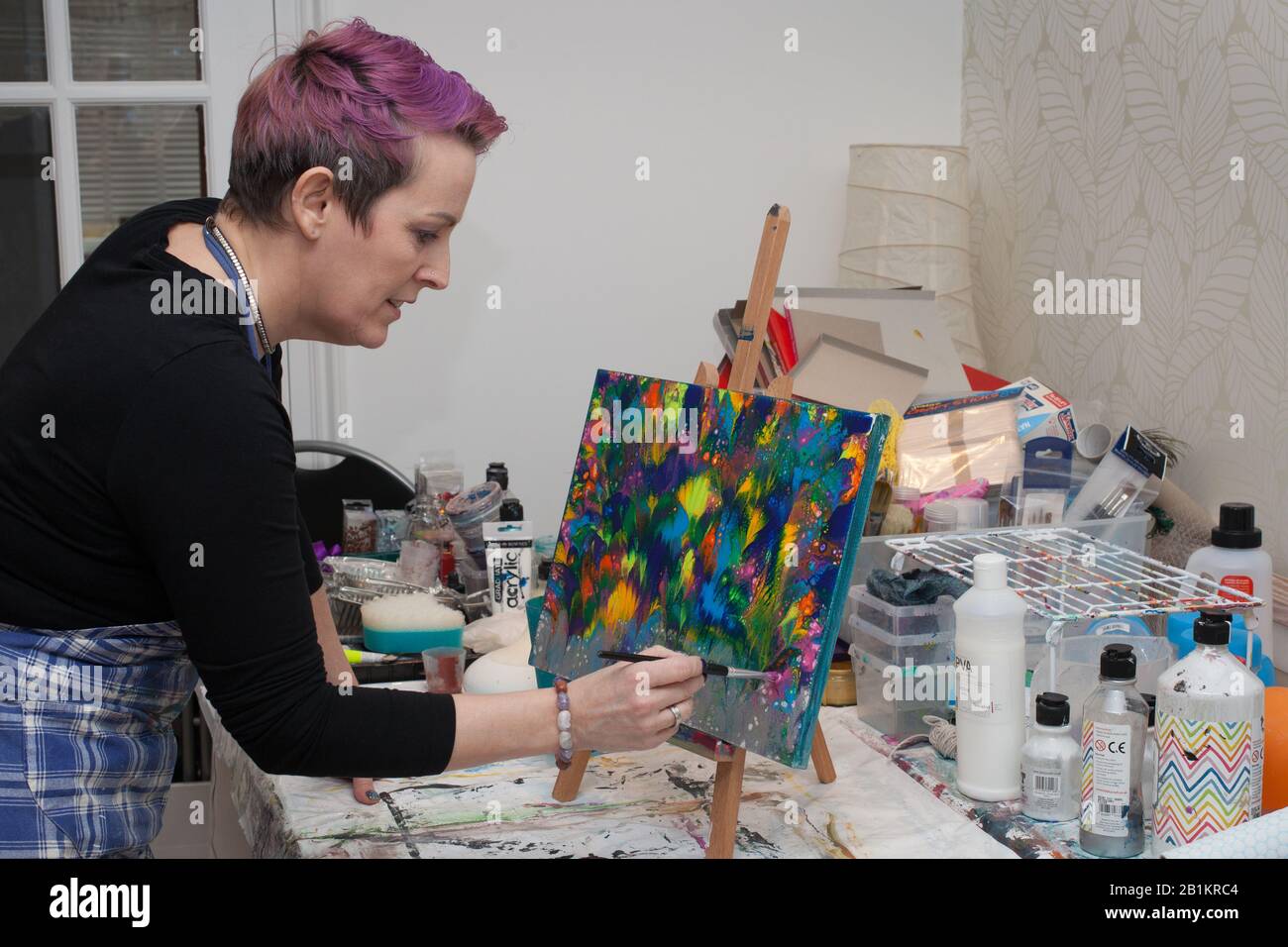 An artist painting an abstract painting in her studio Stock Photo - Alamy