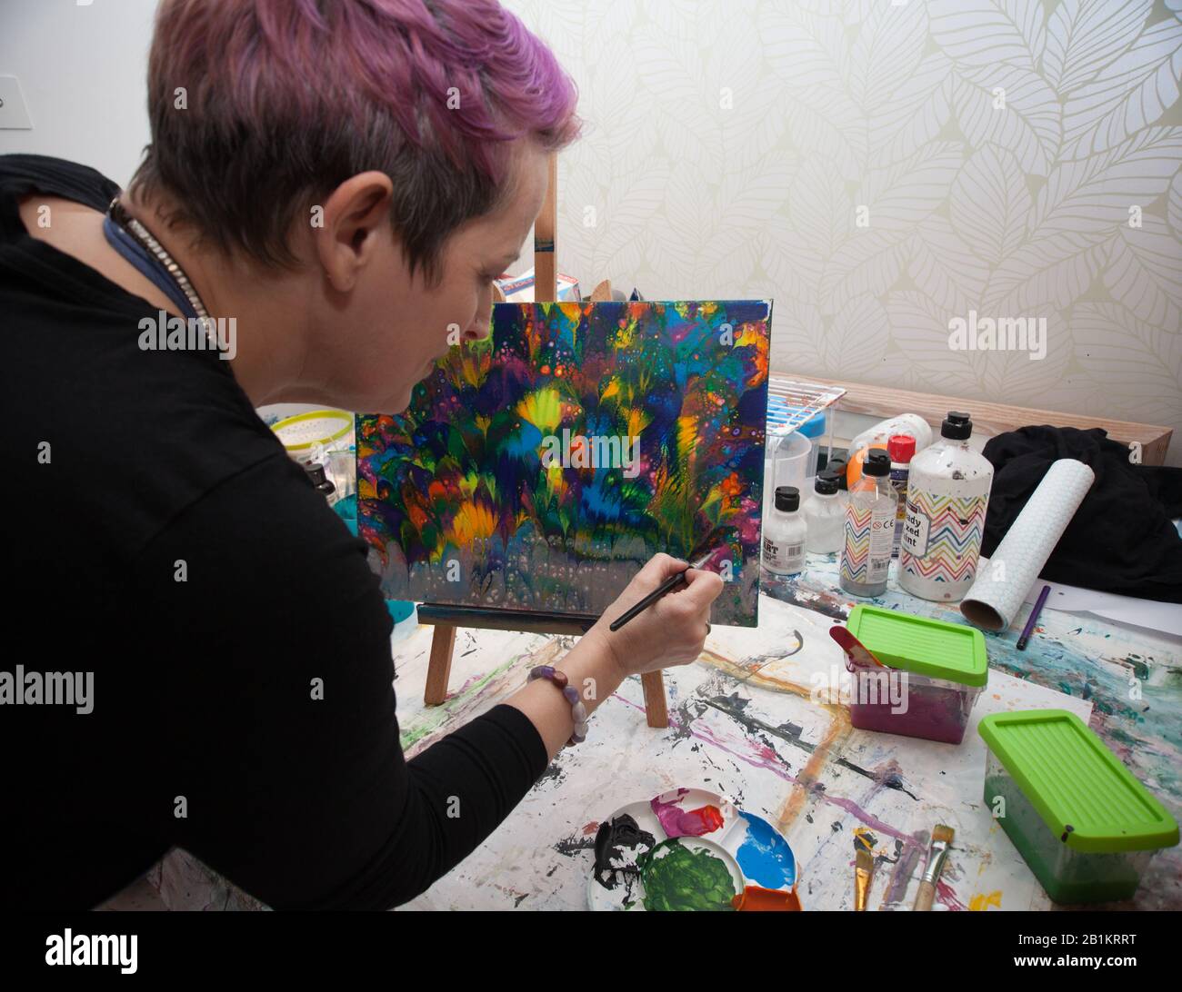 An artist painting an abstract painting in her studio Stock Photo - Alamy